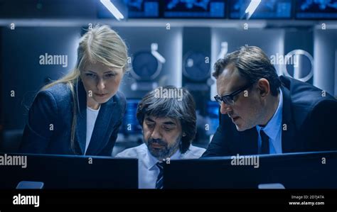 Male And Female Operators Working On Computers In System Control Room Secret Government Agency