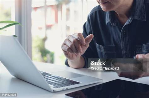 노트북 컴퓨터에서 작업하고 정보를 검색하고 테이블에 디지털 태블릿이있는 휴대 전화를 사용하는 아시아 비즈니스 맨의 클로즈업 55 59세에 대한 스톡 사진 및 기타 이미지