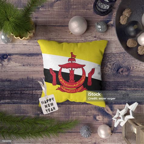베개에 브루나이 플래그와 함께 행복 한 새 해 태그 사랑 스러운 개체 나무 테이블에 크리스마스 장식 개념 공휴일에 대한 스톡