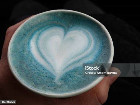 아름다운 하트 모양 라떼 아트 아침 다과와 뜨거운 나비 완두콩 라떼의 여성 손 Hplding 환경 친화적 인 컵 라떼에 대한