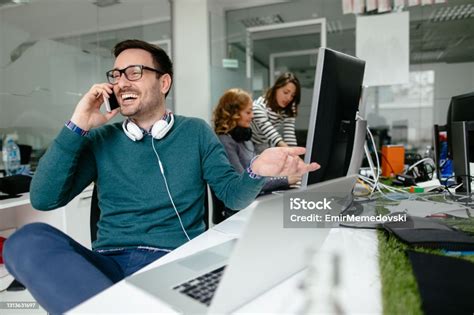 노트북에서 작업하는 동안 전화로 말하는 젊은 남성 컴퓨터 프로그래머 사무실에 대한 스톡 사진 및 기타 이미지 사무실 It