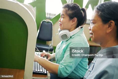 실명 장애가있는 아시아 여성 컴퓨터 키보드와 점자 디스플레이 보조 장치를 사용하여 사무실 직장에서 고위 동료 여성과 함께 작업합니다 실명에 대한 스톡 사진 및 기타 이미지