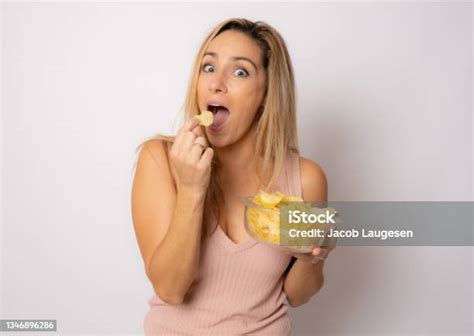젊은 아름다운 여자는 매우 행복 흰색 배경 위에 서 칩 감자를 먹고 먹기에 대한 스톡 사진 및 기타 이미지 먹기 여자 명랑한 Istock