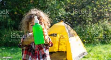 소녀는 그녀의 손과 발을 물린 자연에서 피부에 모기 스프레이를 스프레이합니다 곤충 물림으로부터 보호 어린이를위한 구충제 안전