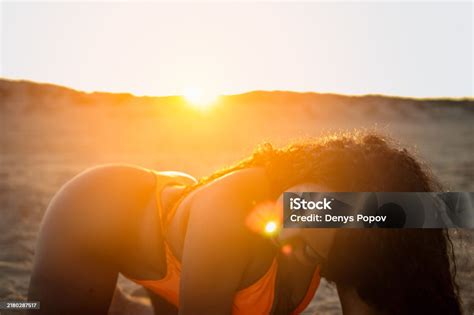 곱슬 머리를 가진 아프리카 계 미국인 멋진 젊은 여성이 배경에 해가 질 때 해변에 등을 굽히고 있습니다 25 29세에 대한 스톡 사진 및 기타 이미지 Istock