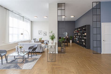 미니멀리스트 현대 인테리어 디자인 중앙에 기둥이있는 흰색 파란색 및 진한 파란색 색상의 스칸디나비아 스타일의 오픈 플랜이있는 거대한 밝은 아파트입니다 주방 공간 사무실 및