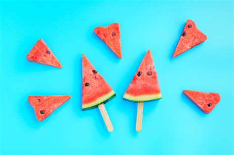 파란색 파스텔 배경에 나무 아이스크림 스틱으로 얇게 썬 수박 과일 수박 아이스크림 수박 아이스 캔디 여름 개념 0명에 대한 스톡