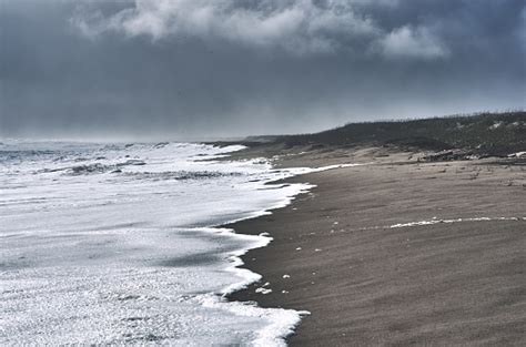 폭풍우가 몰아치는 바다 갈색 어두운 해변 모래와 폭풍 구름이 드라마틱한 푸른 하늘에 모래에 대한 스톡 사진 및 기타 이미지 모래 사이클론 파도 Istock