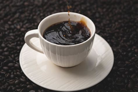 테이블 위의 하얀 컵에 커피를 붓는 모카포트를 들고 있다 볶은 커피 원두의 배경에 분리된 흰색 컵에 담긴 블랙 커피 0명에 대한 스톡 사진 및 기타 이미지 Istock