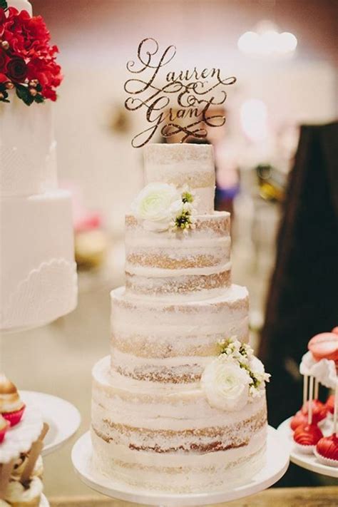 An Elegant Naked Wedding Cake With White Blooms And A Gold Calligraphy