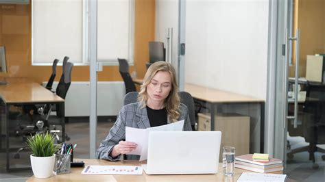 Concentrated Businesswoman Checking And Comparing Each Marketing Report Analyzing Statistics