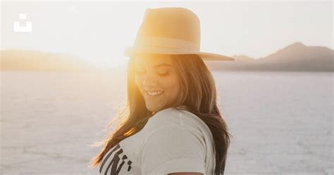 여자는 해질녘 들판에서 미소를 지으며 포즈를 취하고 있습니다 사진 Unsplash의 무료 여자 이미지