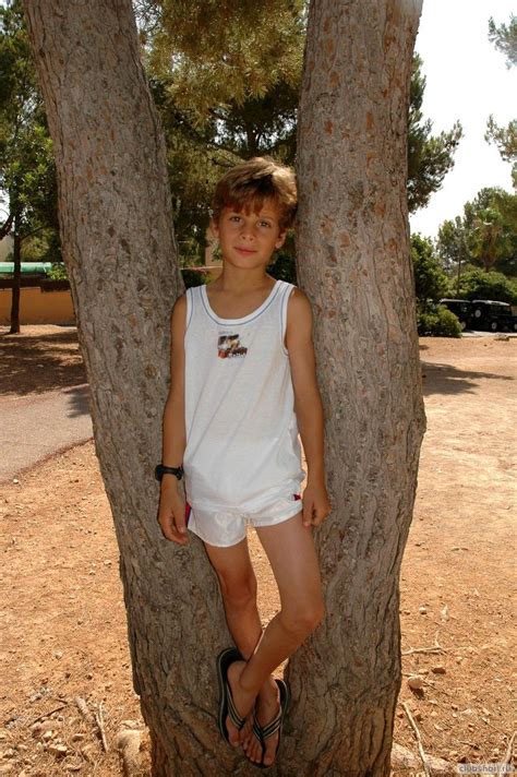 Мальчик в белых шортах зажат между деревьями Шорты фото
