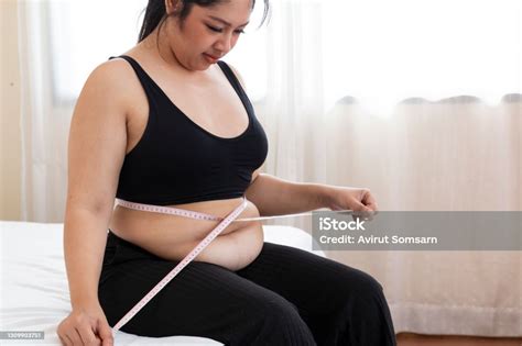 과체중 여성은 측정 테이프를 사용하여 지방 배를 통해 강조 허리를 측정하는 과체중 여성 테이프 측정지방 여성 그녀는 여분의