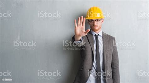 건축가 옷을 입고 빨간 머리 젊은 남자와 오픈 손으로 하 고 심각 하 고 자신감 표현 방어 제스처와 정지 신호 Helment 건설 산업에 대한 스톡 사진 및 기타 이미지