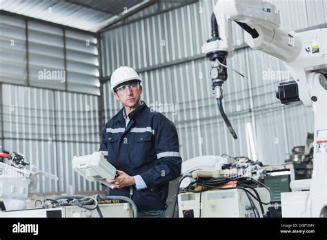 Engineer Controlling Robot Arm At Factory Checking The Operation Of Robot Arm Technology