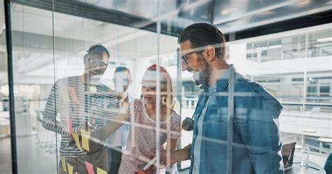 사무실의 현대적인 회의실 유리 벽에 스티커 메모로 브레인스토밍하는 다양한 사업가들의 미소 짓는 그룹 사진 Unsplash의 Ux 연구 이미지