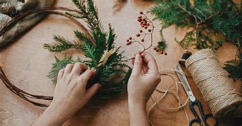소박한 크리스마스 화환 만들기 열매 전나무 가지 솔방울 실 나무 테이블에 가위를 들고 있는 손 정통 시골 화환 크리스마스 화환 워크숍 사진 Unsplash의