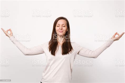 눈을 감고 가벼운 옷에 편안한 젊은 여자 요가 제스처에 손을 잡고 명상 흰색 배경에 고립 된 휴식 사람들은 진심으로 감정 라이프 스타일 개념입니다 복사 공간을 모의 합니다