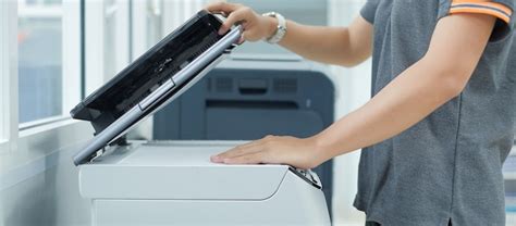 Premium Photo Hand Putting A Document Paper Into Printer Scanner Laser Copy Machine In Office