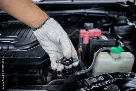 Close Up Of Hand Of A Gloved Mechanic Opening The Radiator Cap To Check The Coolant Level A Man