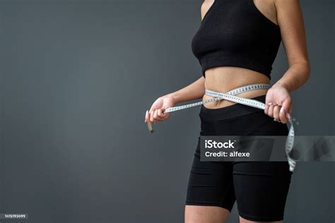 웃는 여자는 줄자로 이상적인 허리를 측정하고 다이어트의 결과를 보여줍니다 다이어트에 대한 스톡 사진 및 기타 이미지 다이어트 필라테스 속도 Istock