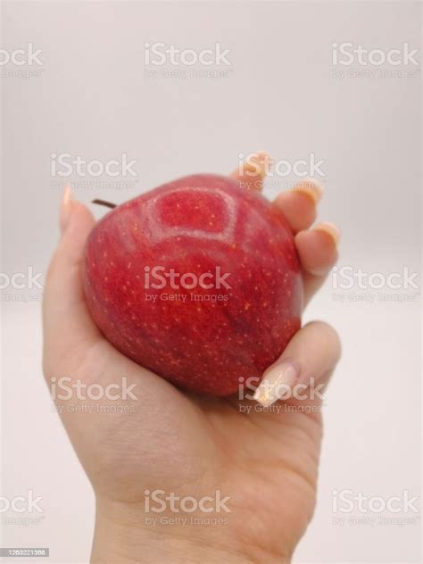 긴 매큐징 손톱 을 가진 젊은 여성의 손은 빛 배경에 잘 익은 빨간 줄무늬 사과를 들고 있습니다 건강한 식습관의 개념 베이비 붐 세대에 대한 스톡 사진 및 기타 이미지