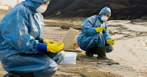 더러운 물 샘플을 들고 있는 젊은 여성 생태학자는 위험한 지역에서 물의 특성에 대한 데이터를 입력하는 동료를 보고 있습니다 사진 Unsplash의 산업 이미지