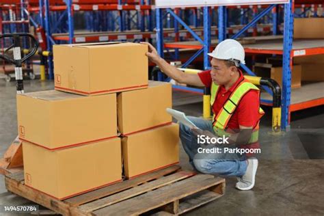 Saftyhat 및 반사 재킷 체크리스트를 가진 창고 작업자 남자 또는 소매 창고 물류 유통 센터의 생산 재고 및 재고로 배달하기 위한 대형 상자 패키지를 제어합니다 30