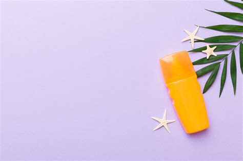 자외선 차단제 스프레이 병 태양 보호 크림과 색상 배경에 열대 녹색 잎이있는 바다 껍질이있는 병 상단 전망 0명에 대한 스톡