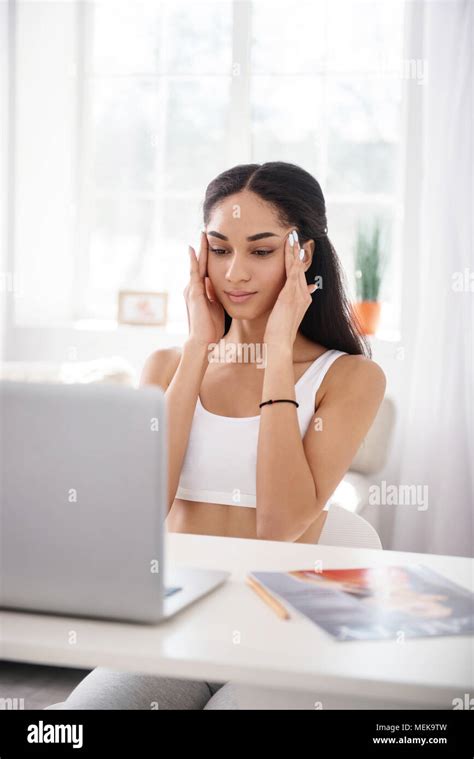 Beautiful Woman Massaging Her Temples While Sitting At Table Stock