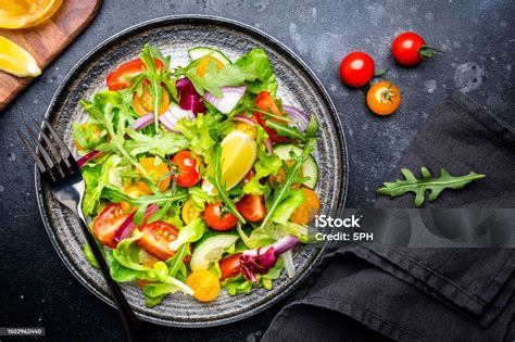 다채로운 토마토 신선한 오이 적양파 양상추 루꼴라를 곁들인 여름 비건 야채 샐러드 검은색 테이블 배경 평면도 건강한 식생활에 대한 스톡 사진 및 기타 이미지 Istock