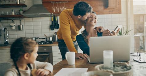 남편이 집에서 그녀에게 키스하는 동안 메모를 하고 컴퓨터에서 작업하는 행복한 여자 사진 Unsplash의 집에 있는 사람들 이미지