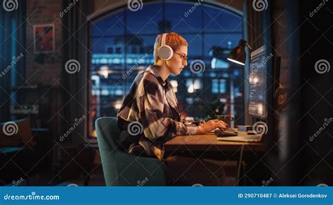 Young Woman Writing Code On Desktop Computer In Stylish Loft Apartment