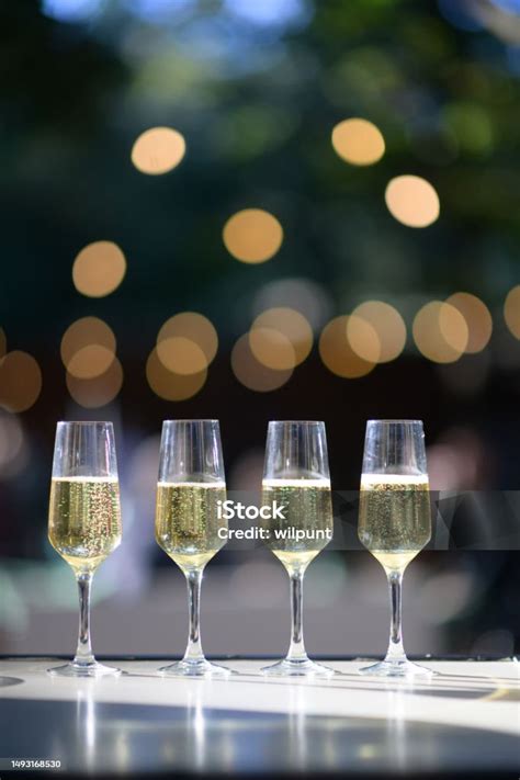 햇볕이 잘 드는 야외 여름 샴페인 플루트와 초점이 흐려진 스트링 라이트 보케 샴페인 와인에 대한 스톡 사진 및 기타 이미지 샴페인 와인 이벤트 레스토랑 Istock