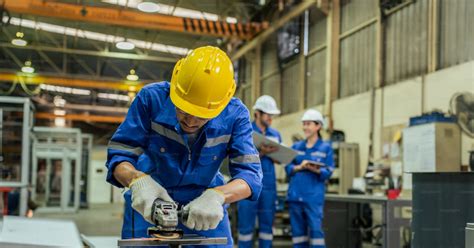 제조 공장에서 일하는 아시아의 매력적인 남자 산업 노동자 젊은 잘 생긴 남성 산업 공장 엔지니어는 헬멧을 착용하고 행복하게 제조소 창고에서 주문과 제품을 처리합니다 사진