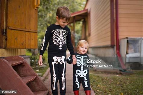 귀여운 아기 소녀와 할로윈의 뒷마당에서 걷는 해골 의상을 입은 어린 소년 할로윈에 대한 스톡 사진 및 기타 이미지 할로윈 공동체 뒤뜰 Istock