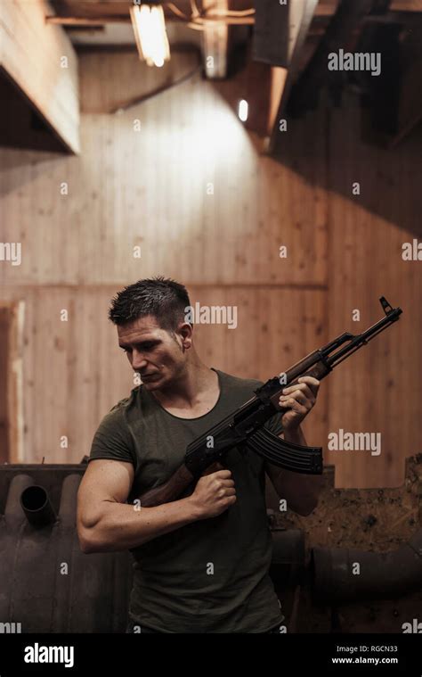 Man Holding A Rifle In An Indoor Shooting Range Stock Photo Alamy