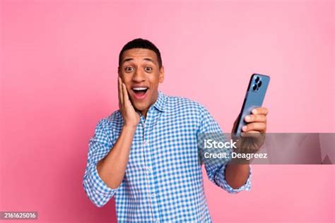잘생긴 Excied 남자의 사진 체크 무늬 셔츠 타이핑 애플 아이폰 삼성 현대 가제트 Emtpy 공간 절연 핑크 색상 배경 Brand Name Smart Phone에 대한