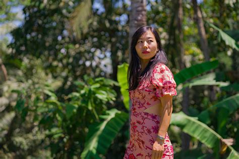 야외 여름 라이프 스타일 초상화 젊은 아름답고 행복한 아시아 한국 여성의 우아한 드레스는 조화와 평온의 녹색 도시 공원이나 나무에서 조용하고 쾌활한 산책 걷기에 대한 스톡