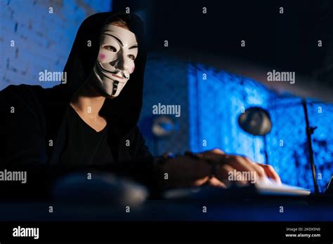 Low Angle View Of Unrecognizable Wanted Hacker Male Wearing Anonymous