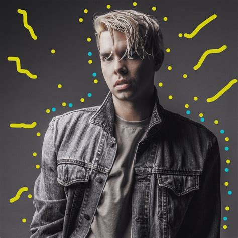 A Man With Blonde Hair Wearing A Denim Jacket