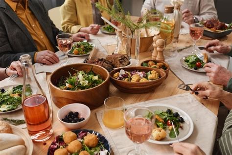 Primer Plano De La Mesa De Comedor Con Comida Y Bebidas Y Gente Sentada