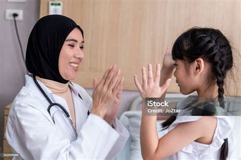 목에 청진기가 달린 유니폼을 입은 소아과 의사가 병원 회의에서 어린 소녀 환자와 즐거운 시간을 보내고 있습니다 의료 보험 배경 의료 종사자 및 의학 치료 개념 2명에 대한