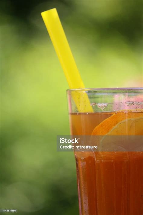 집에서 만든 롱 아일랜드 아이스 티 드링크와 보드카를 사용한 알콜 성 가든 칵테일 외부 파티오 테이블에 미니 레드 장미 꽃 레몬과 얼음 조각으로 미국 식당 유리에 노란색