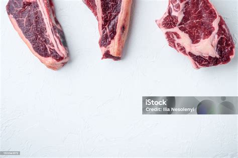 원시 블랙 앵거스 프라임 드라이 숙성 육류 스테이크 토마호크 T 뼈 또는 포터 하우스와 클럽 스테이크 흰색 돌 배경에 상단 보기 플랫 레이 텍스트복사 공간 갈빗살 구이에