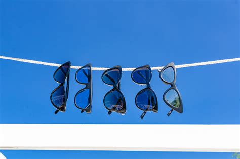 푸른 하늘과 녹색 잎의 배경에 흰색 밧줄에 매달려 다른 선글라스 열대 휴가 태양으로부터 눈의 보호 개인 장식품에 대한 스톡 사진 및 기타 이미지 Istock