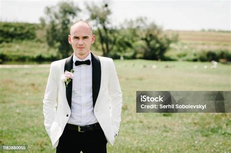 나비 넥타이와 부토니에가 달린 양복을 입은 신랑 신랑턱시도 미소와 신부를 기다리고 결혼식 날에 풍부한 신랑 턱시도에 대한 스톡 사진 및 기타 이미지 Istock