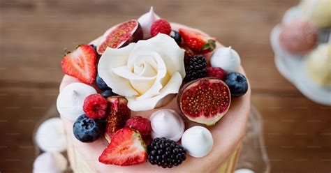 다양한 열매 무화과 머랭 및 흰 장미가 든 케이크 스튜디오 촬영 나무 배경입니다 사진 Unsplash의 블루베리 이미지