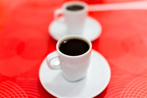 세부 사항 이탈리아 카페 아침 식사에서 접시 빨간색 배경 테이블에 검은 갈색 액체의 텍스처와 매크로 근접 촬영 두 에스프레소 다크 로스트 커피 컵 0명에 대한 스톡 사진 및